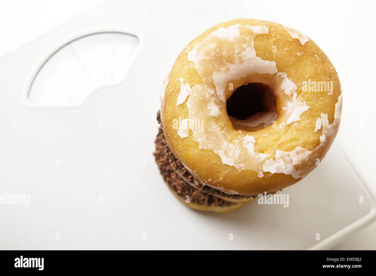 stack of different flavor donuts shot on scale for weighing yourself ...