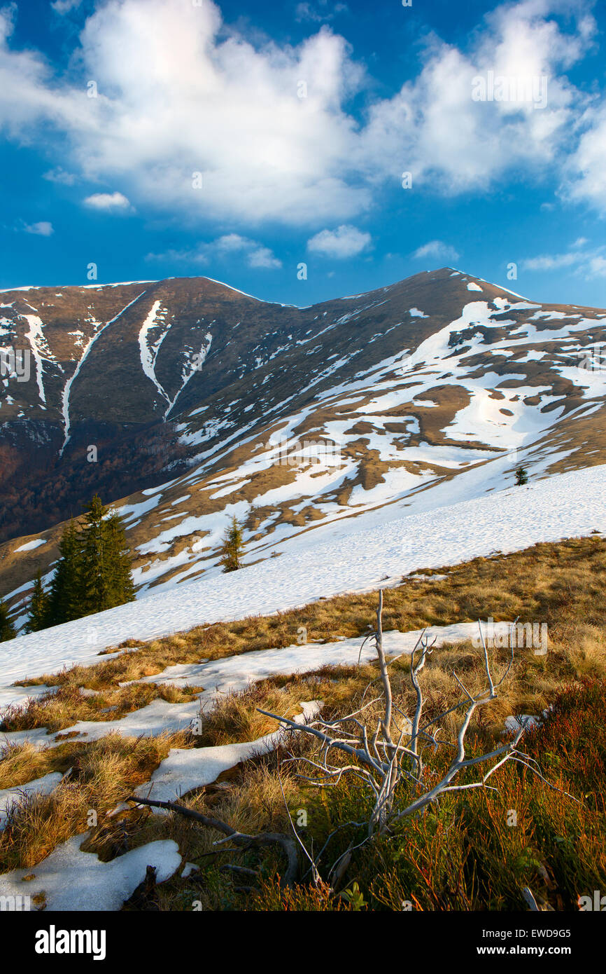 mountain range in early spring. Spots snow beautiful clouds in the sky ...