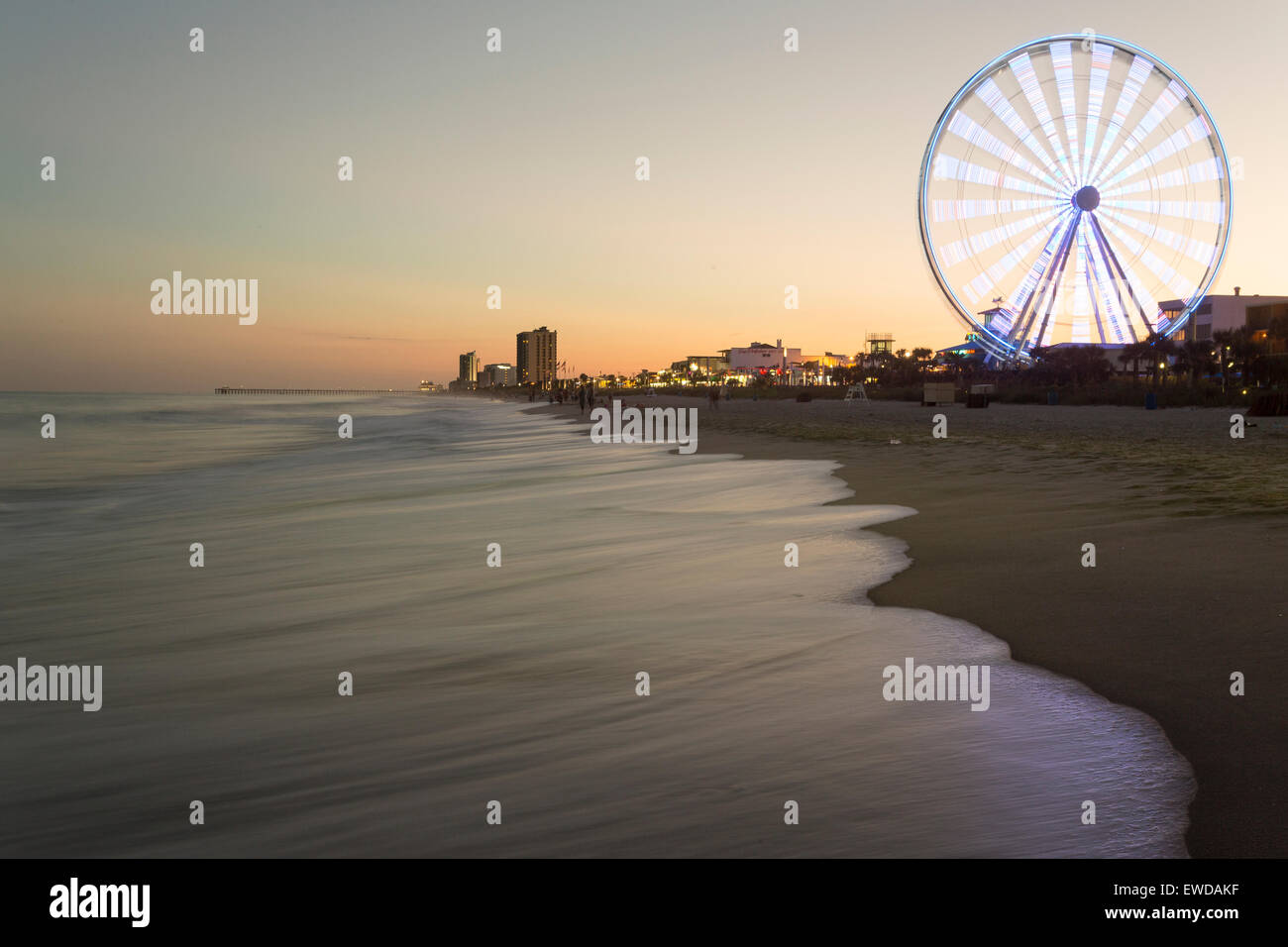 Tourist beach with a ferris wheel, hotels, and visitors Stock Photo - Alamy