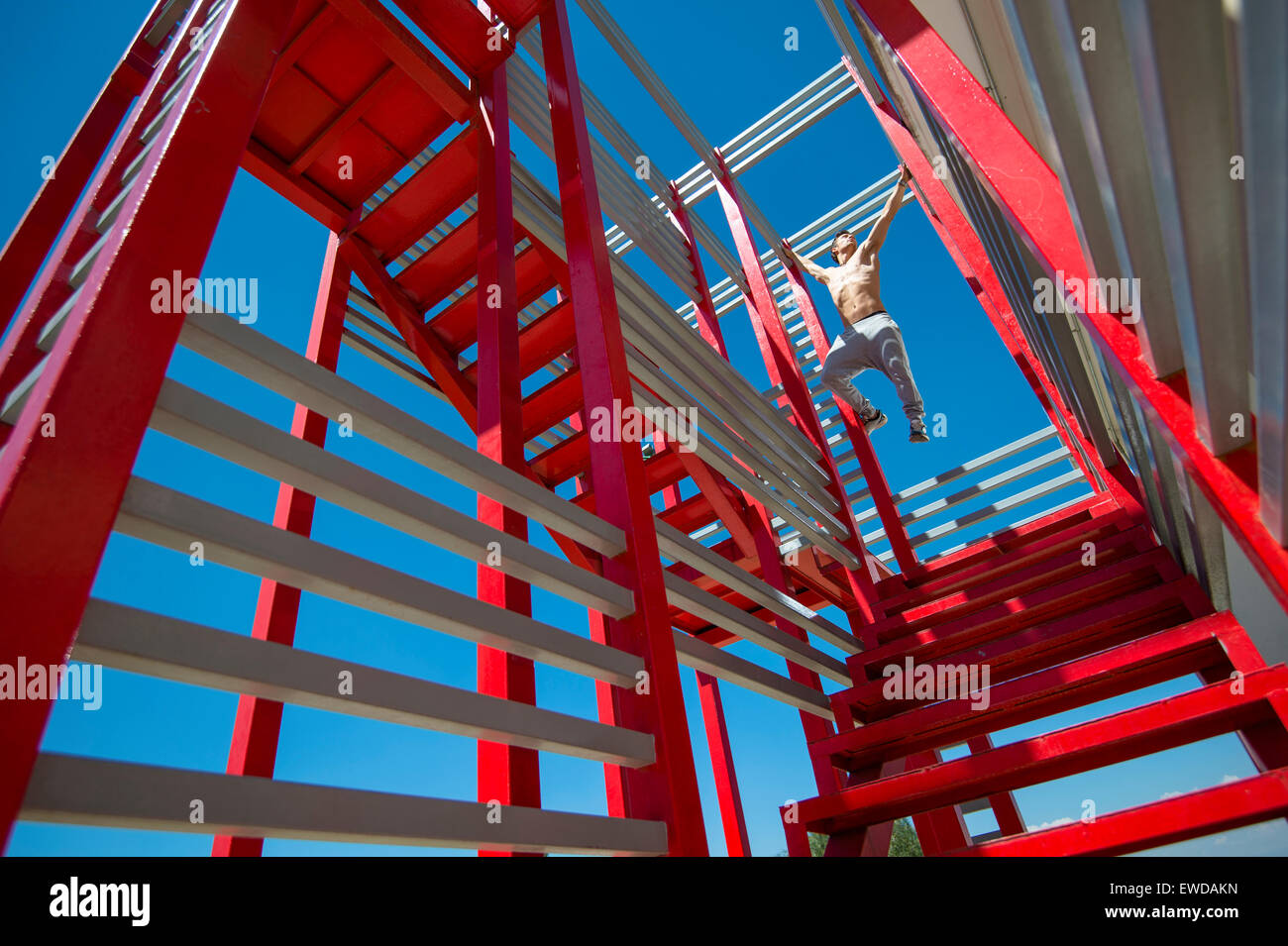 Chase Armitage free running on a red metal structure Stock Photo - Alamy