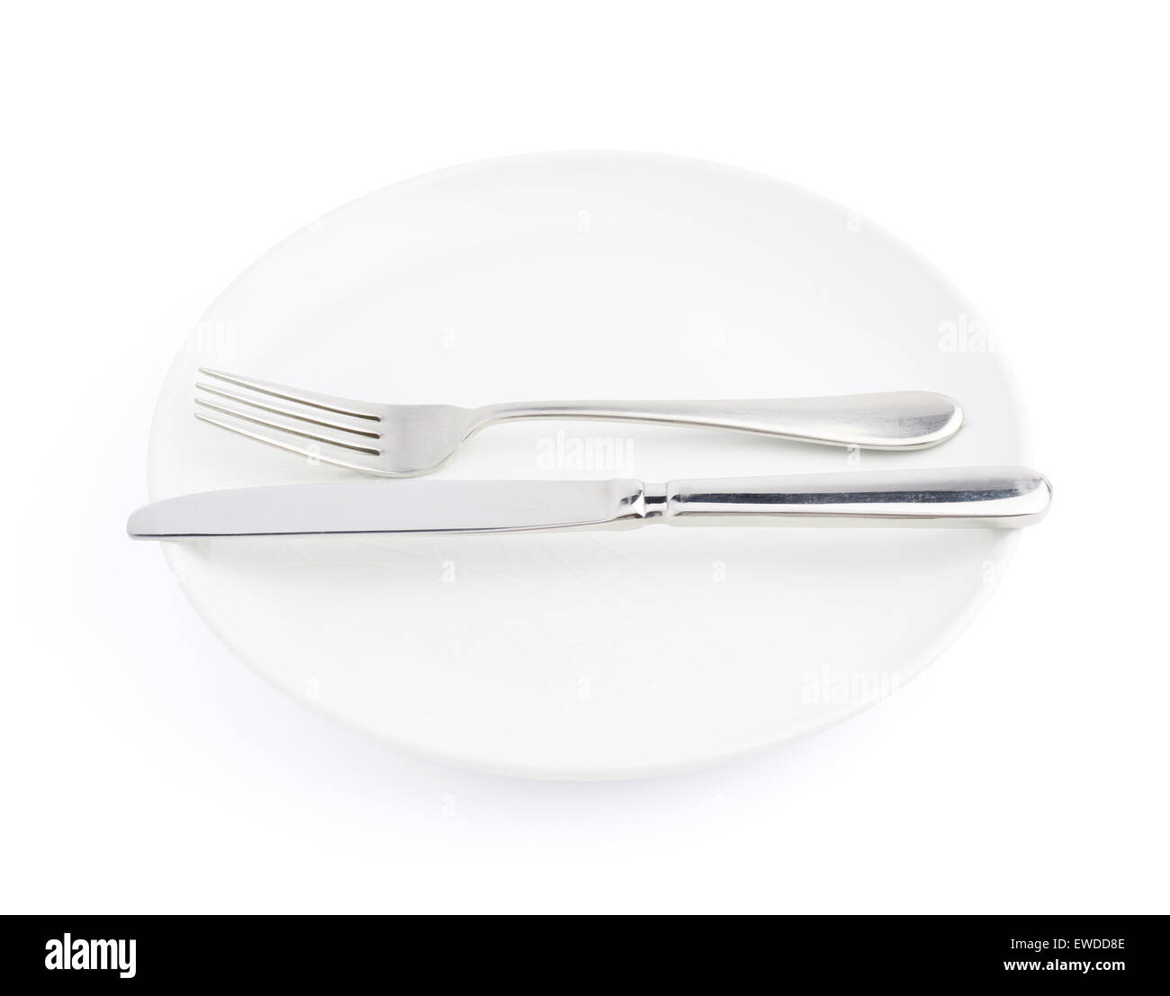 Knife and fork over the plate isolated Stock Photo - Alamy
