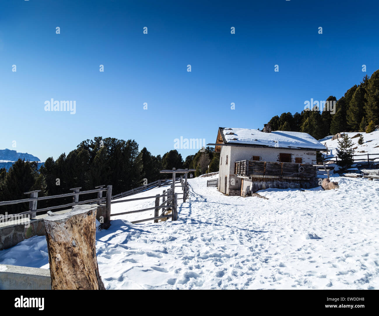 Alpine chalet surrounded by a fence in the snow in front of a panorama ...