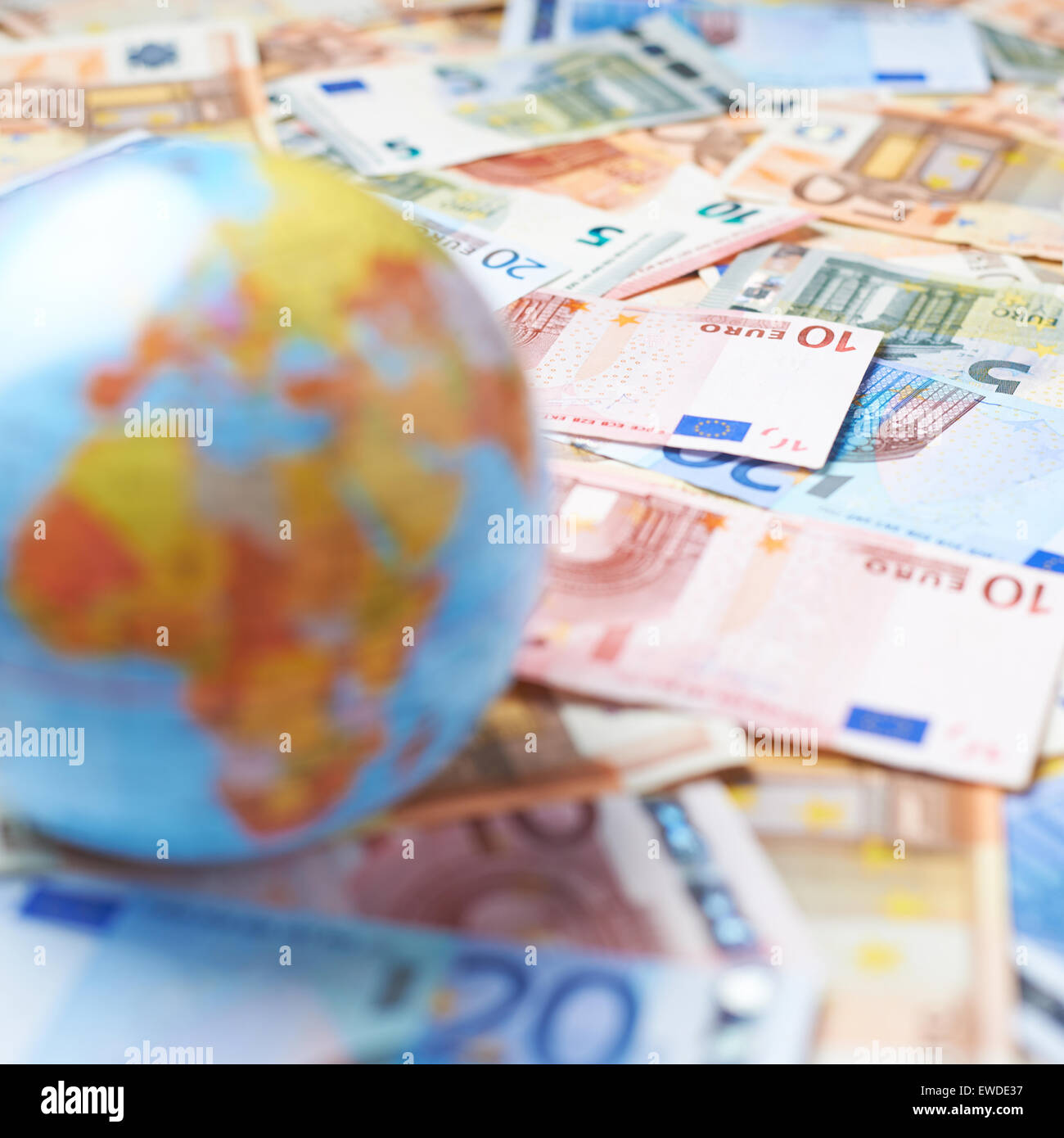 Earth globe over the pile of money Stock Photo - Alamy