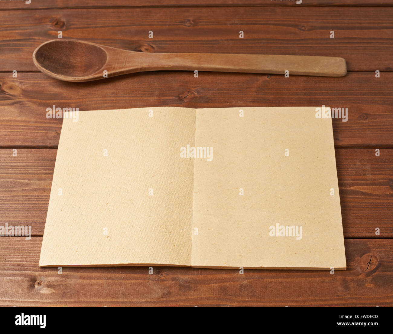 Wooden spoon next to recipe book Stock Photo - Alamy
