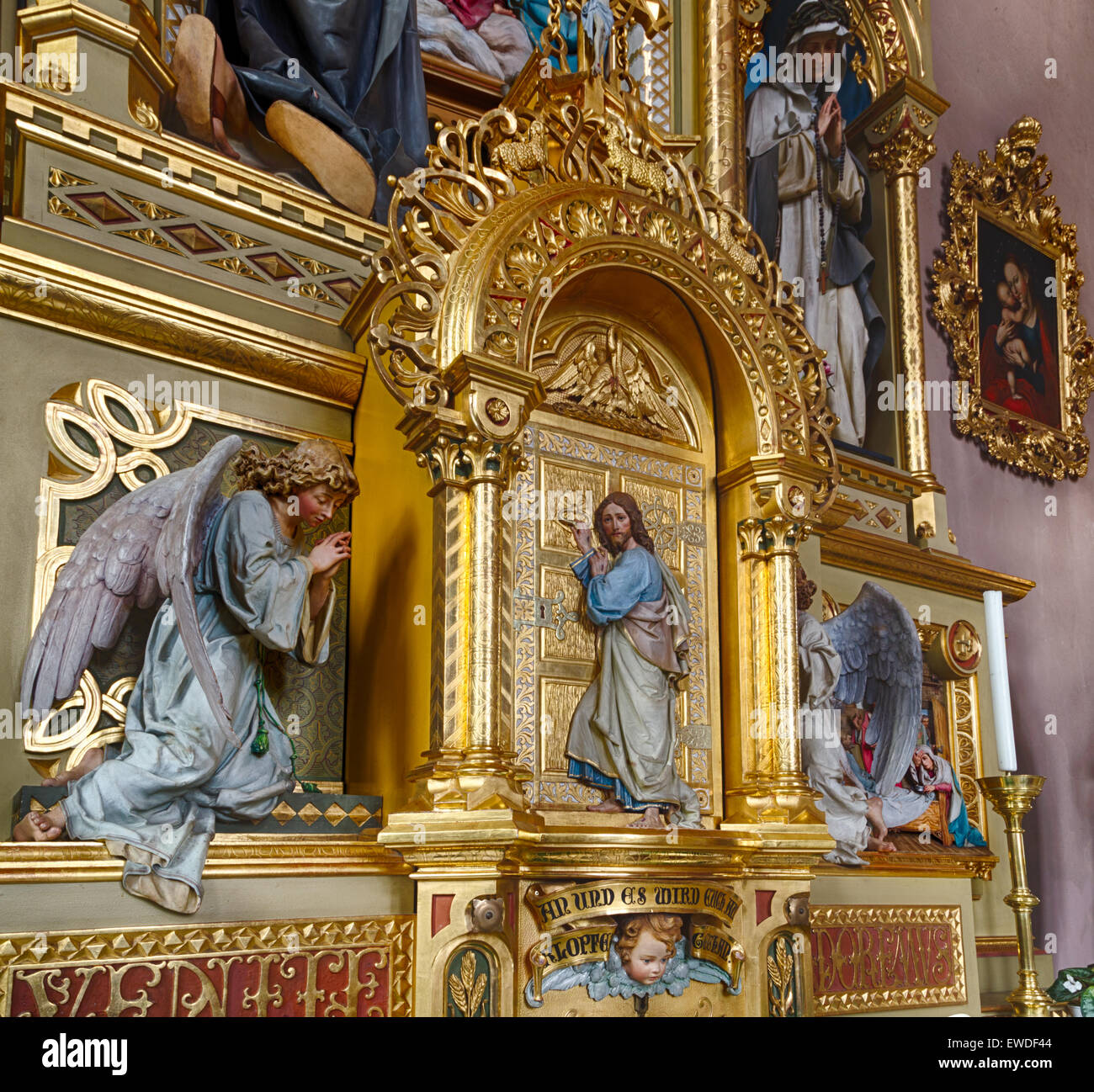 Wood carved statue of Jesus Christ between two angels standing at a ...
