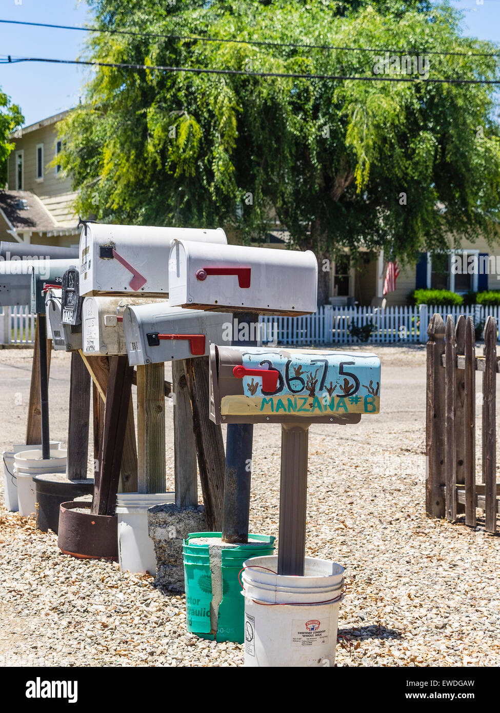 A rural group of mail boxes all free standing and set in buckets of ...