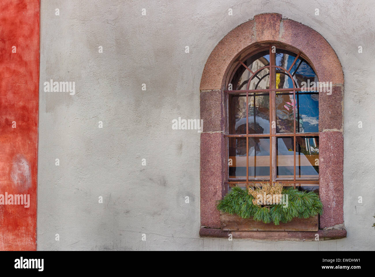 Squared ancient glass window with rounded stone frame and iron grate ...