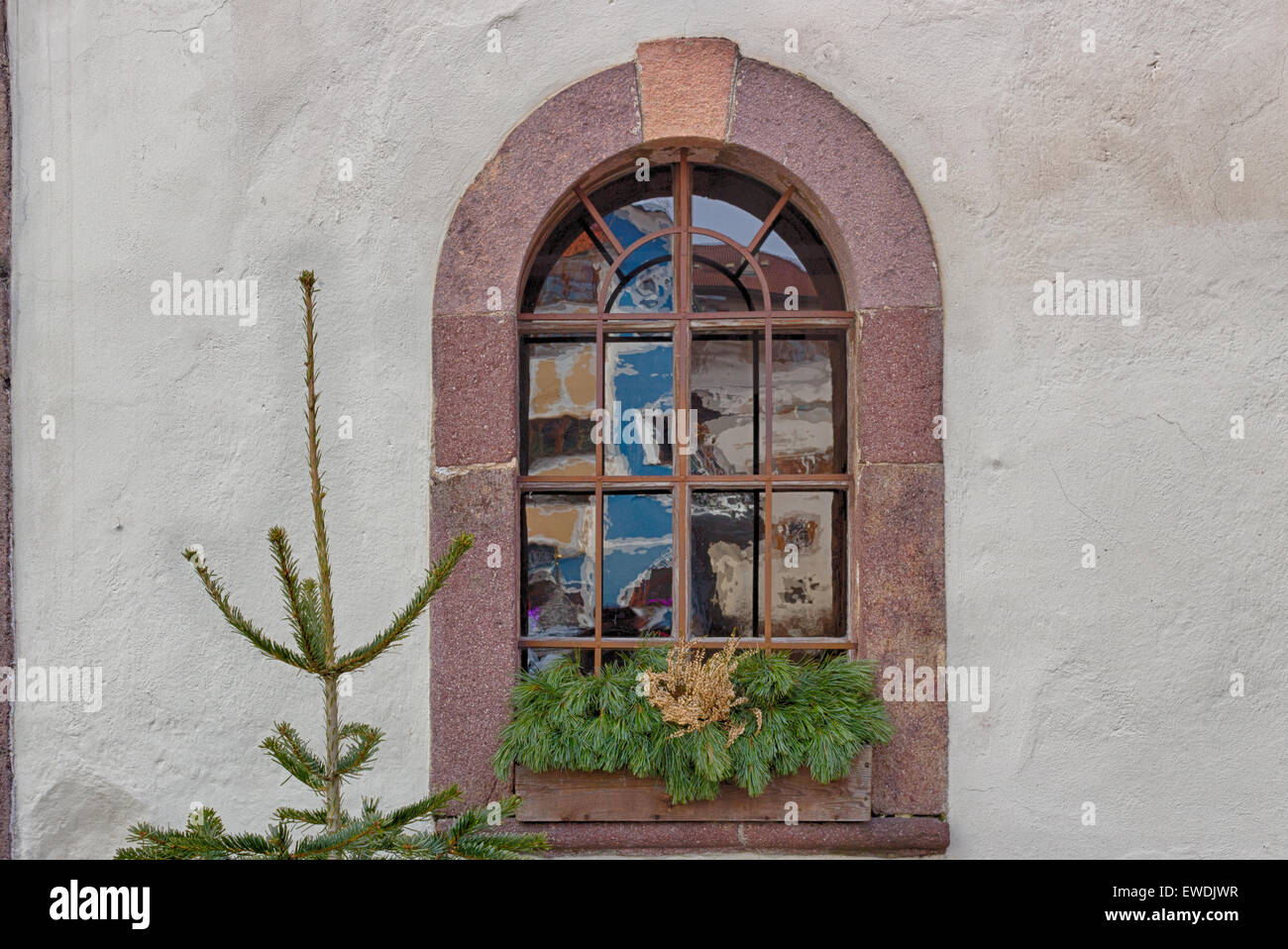 Squared ancient glass window with rounded stone frame and iron grate ...