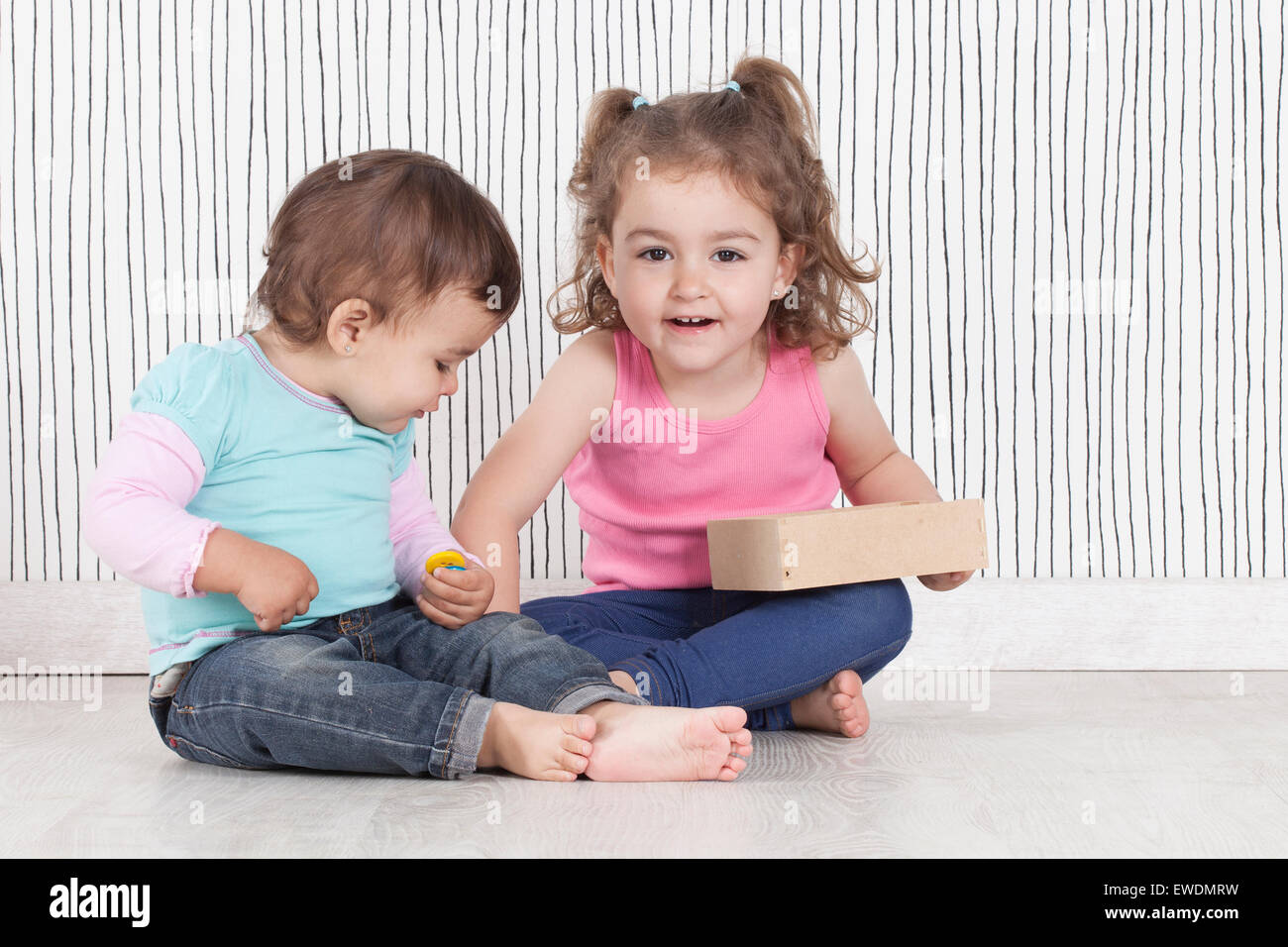 two little sister playing with some buttons Stock Photo - Alamy