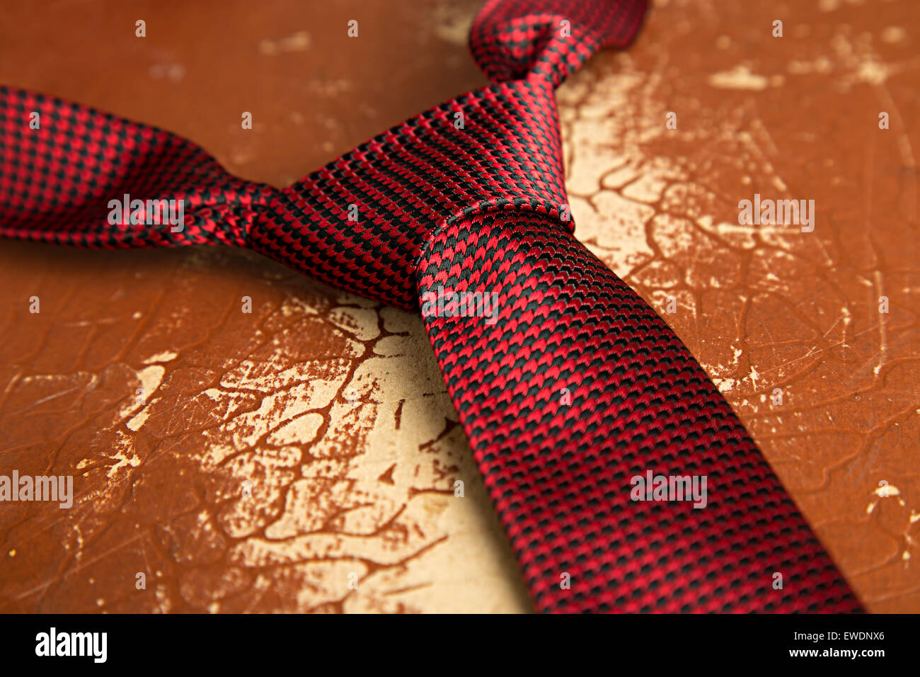 Red tie with Windsor knot on a old grunge suitcase as a background ...
