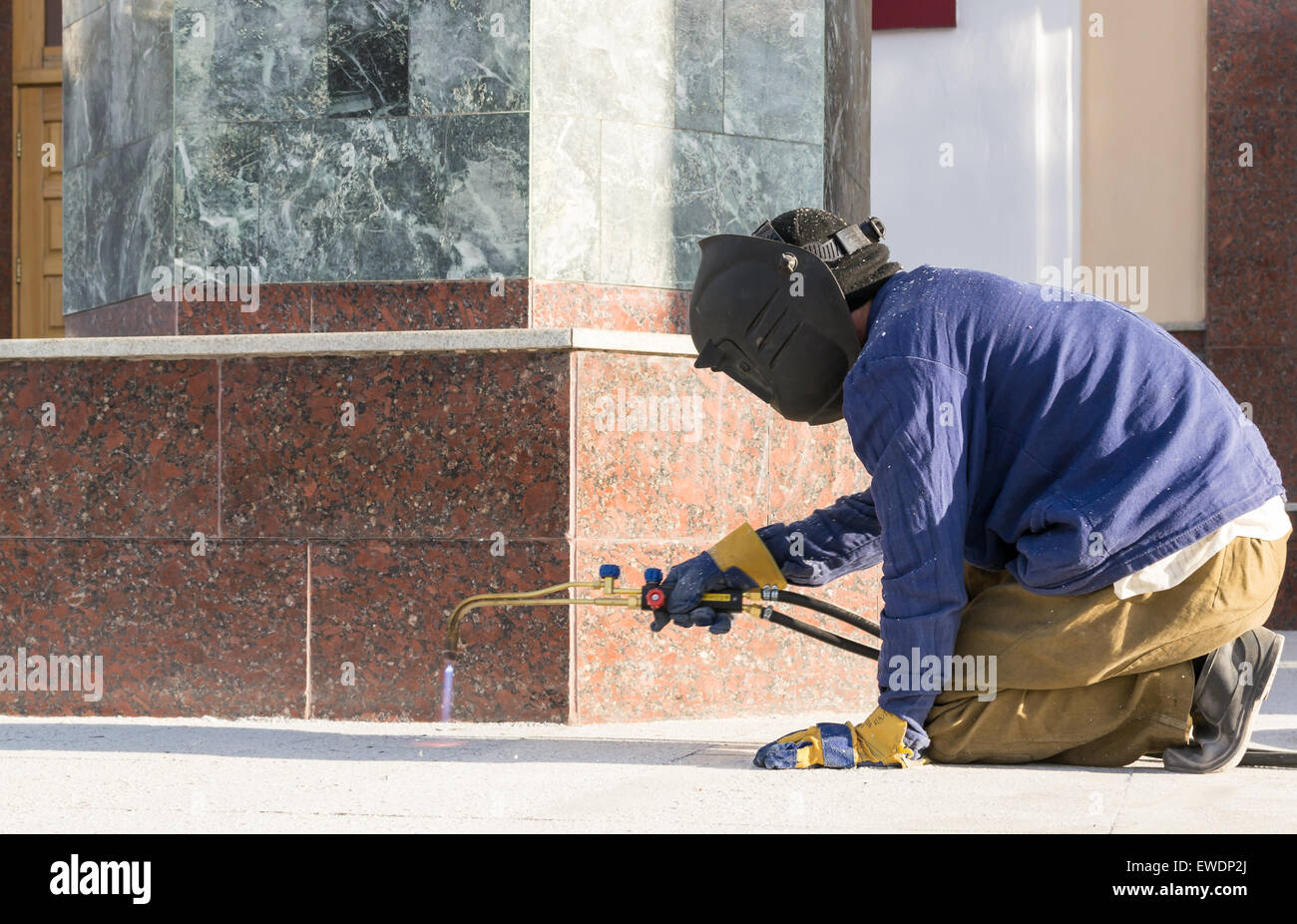 City construction worker welding metal rods with protective face mask ...