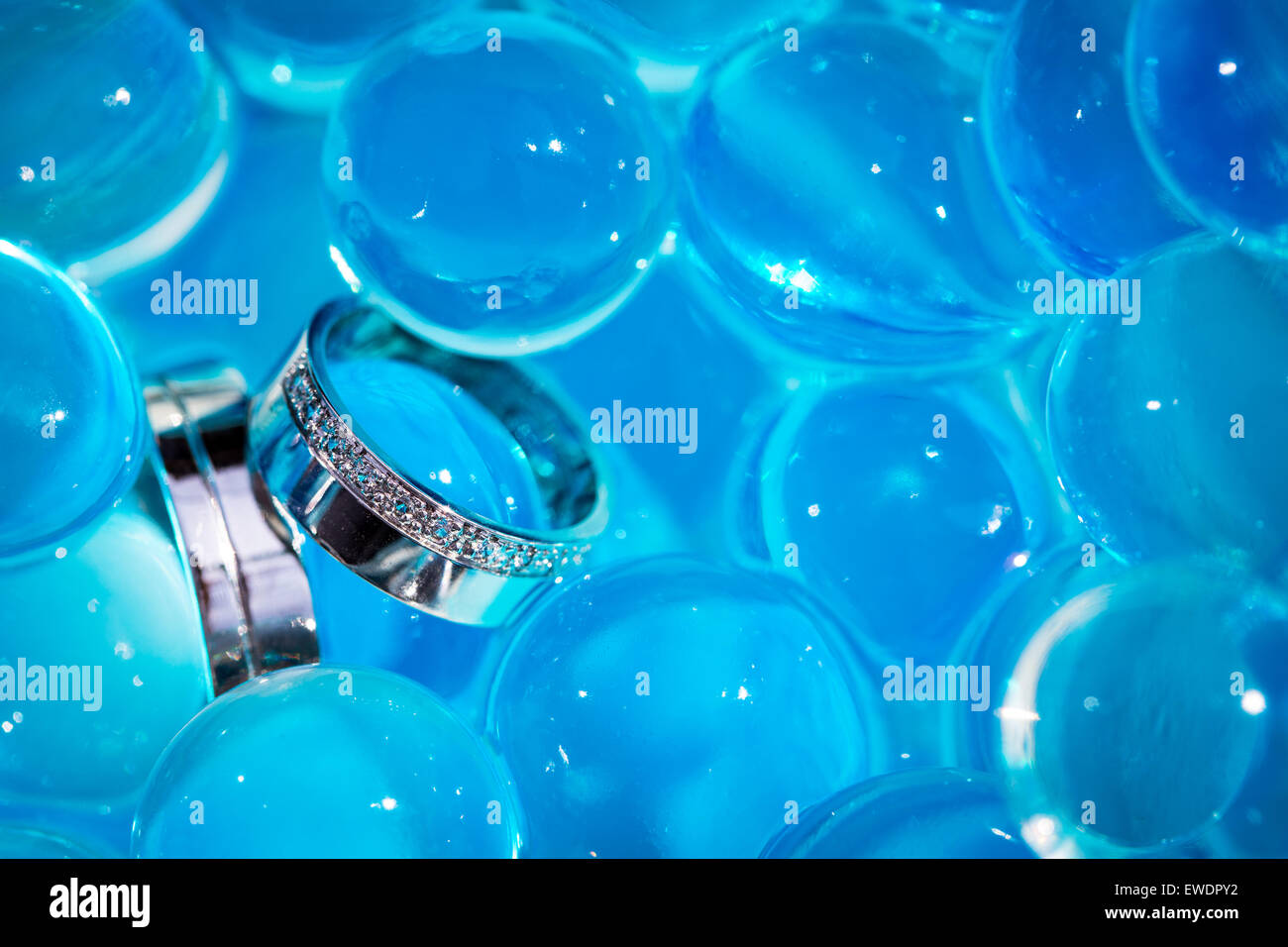Wedding rings amid blue balls Stock Photo - Alamy