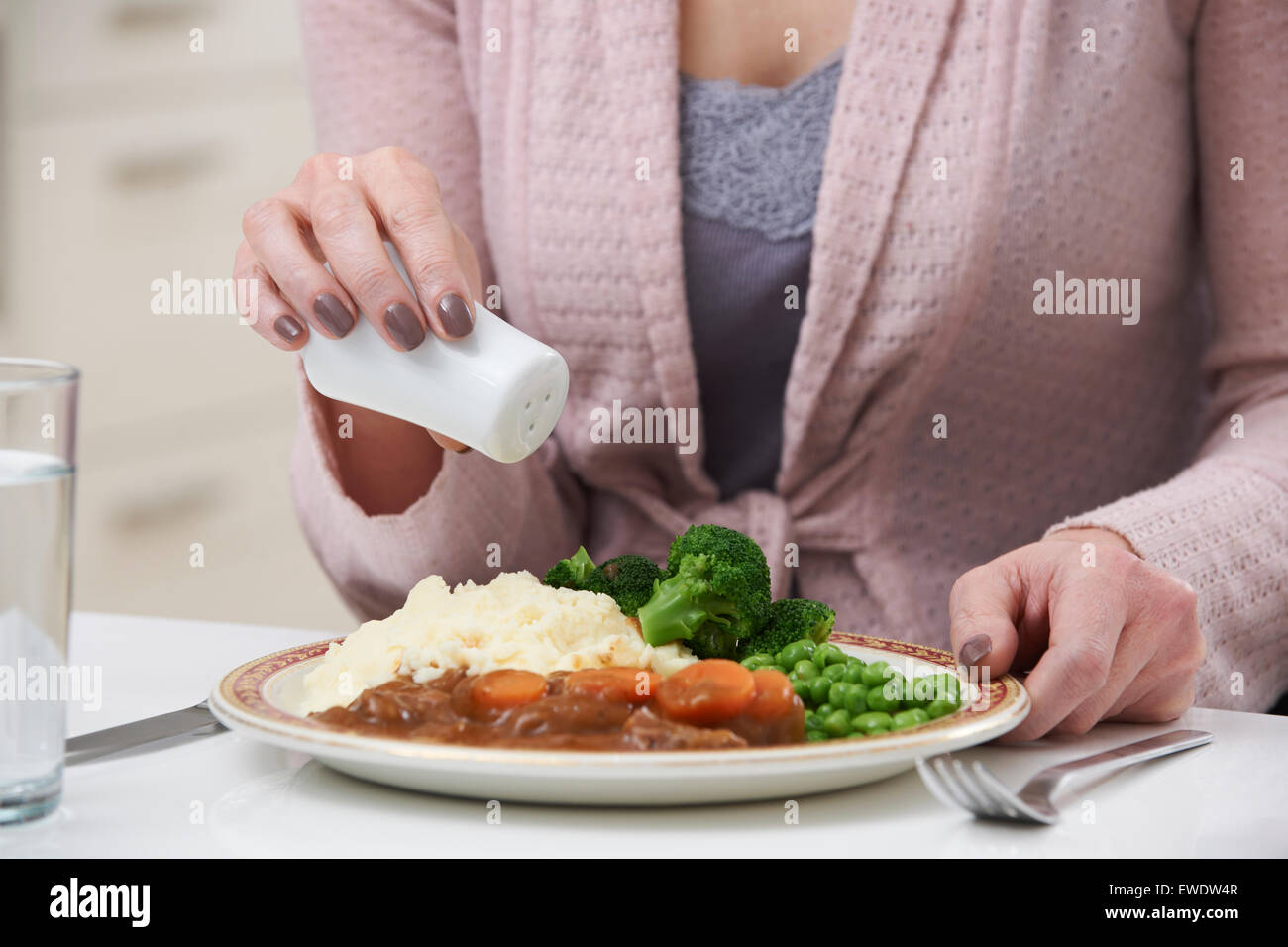 Woman adding salt to food hi-res stock photography and images - Alamy