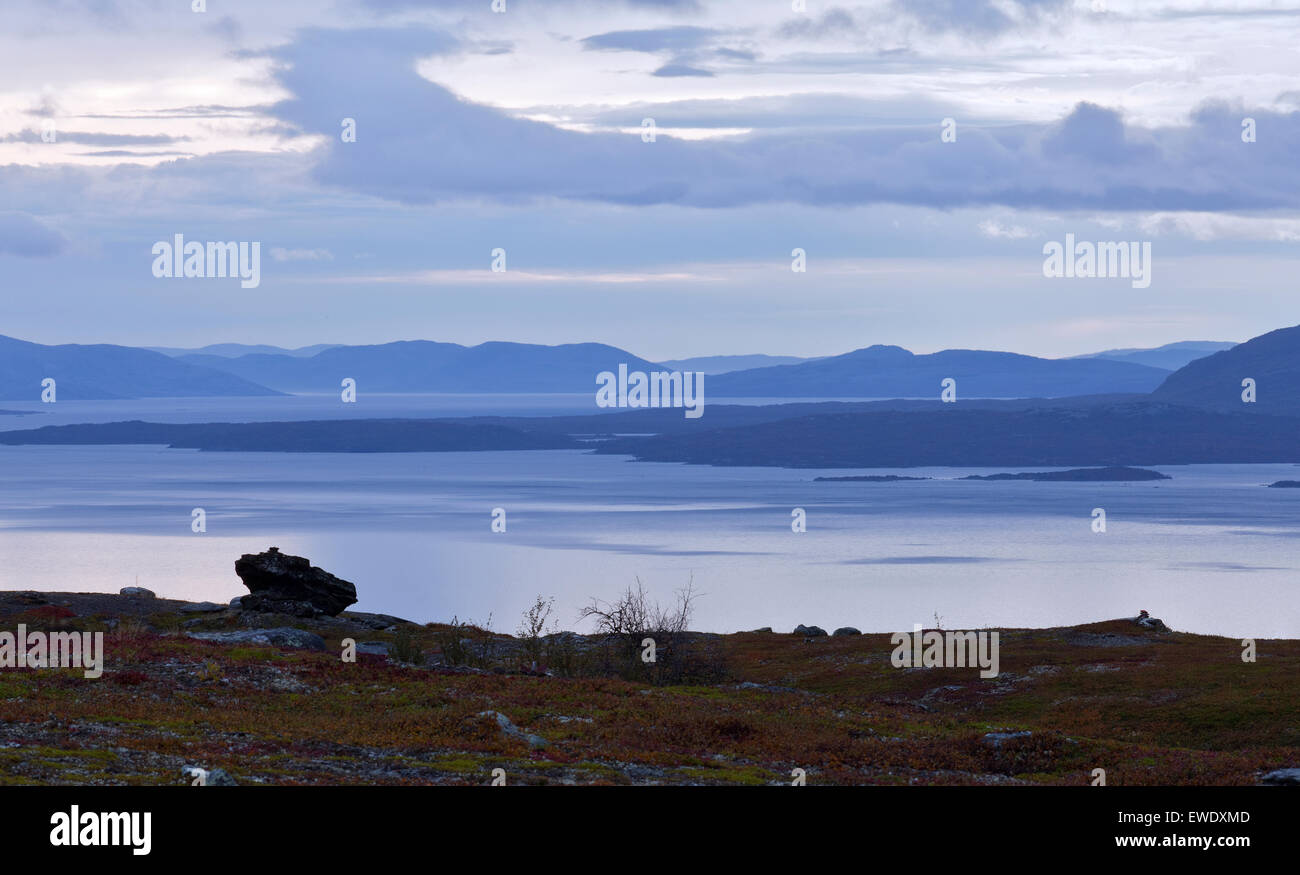 Overcast morning view of a lake and mountain. Stones, creepers on the ...