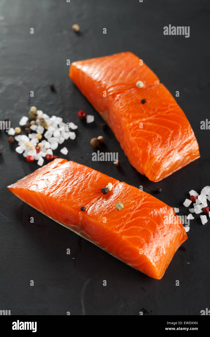Two pieces Salmon with herbs on black background Stock Photo - Alamy