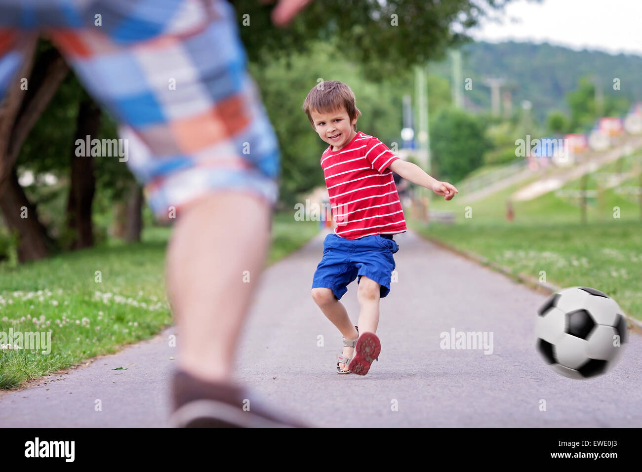 Two cute little kids, playing football together, summertime. Children ...