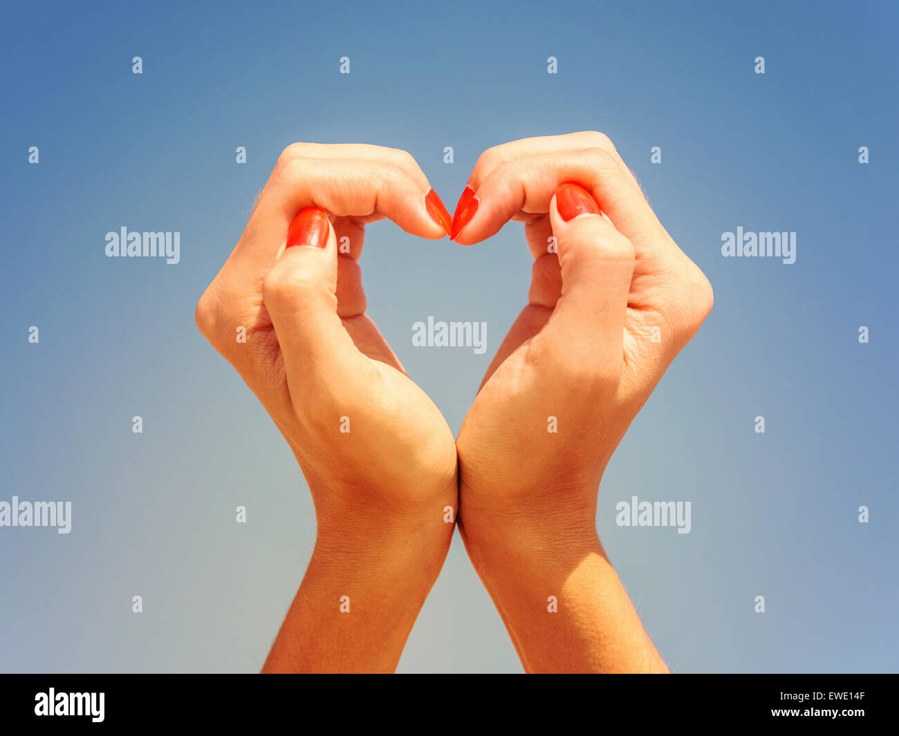 Retro Filter Of Girl Hands In Heart Shape On Blue Sky Stock Photo - Alamy