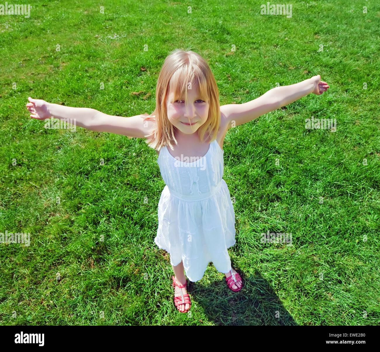 beautiful child with raised standing on green grass Stock Photo - Alamy