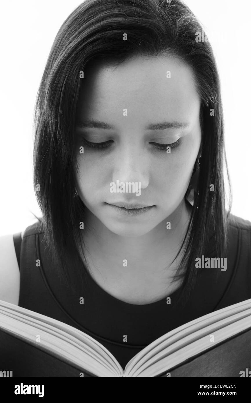 close up portrait of young woman reading a hard backed book Stock Photo ...