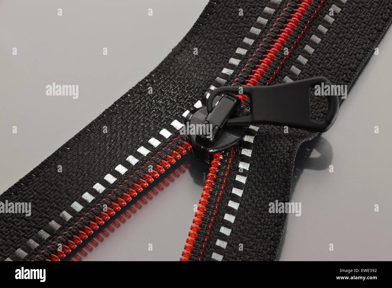 Black zipper with red line opened to a gray surface Stock Photo - Alamy