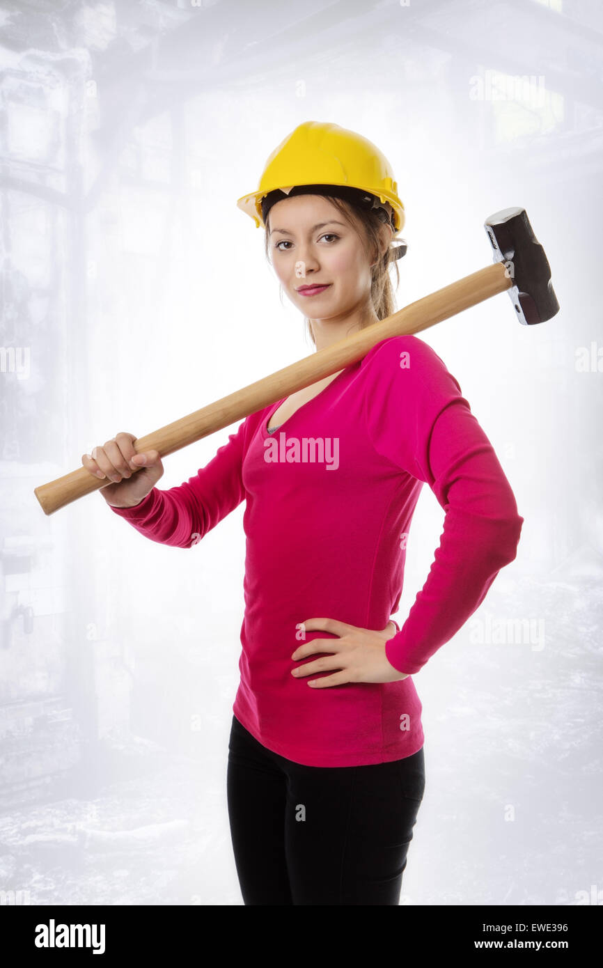 woman holding a sledgehammer and wearing a hard hat about to smash ...