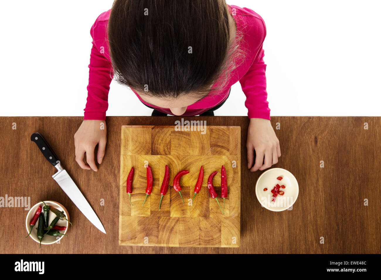 woman about to chop up chillis on a wooden chopping board taken from a ...
