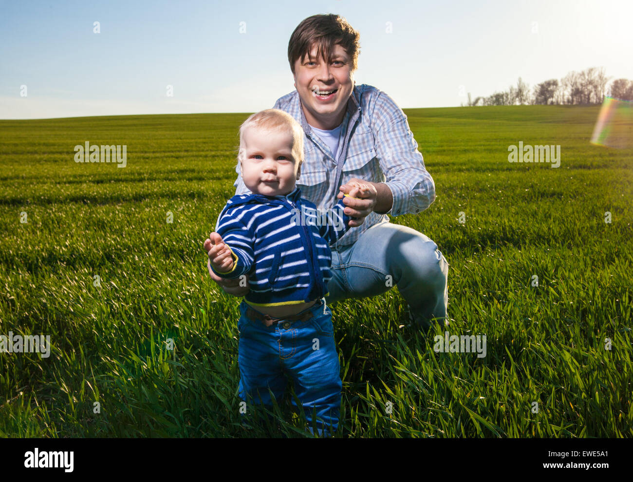 father and baby having fun, playing on green field Stock Photo - Alamy