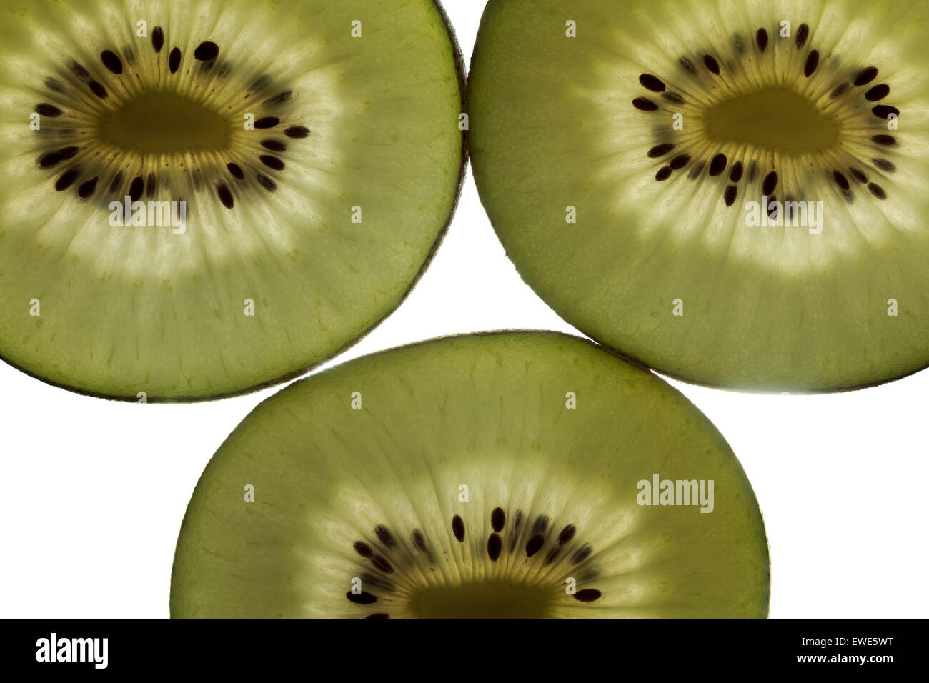 Three back lit slices of golden kiwi Stock Photo - Alamy