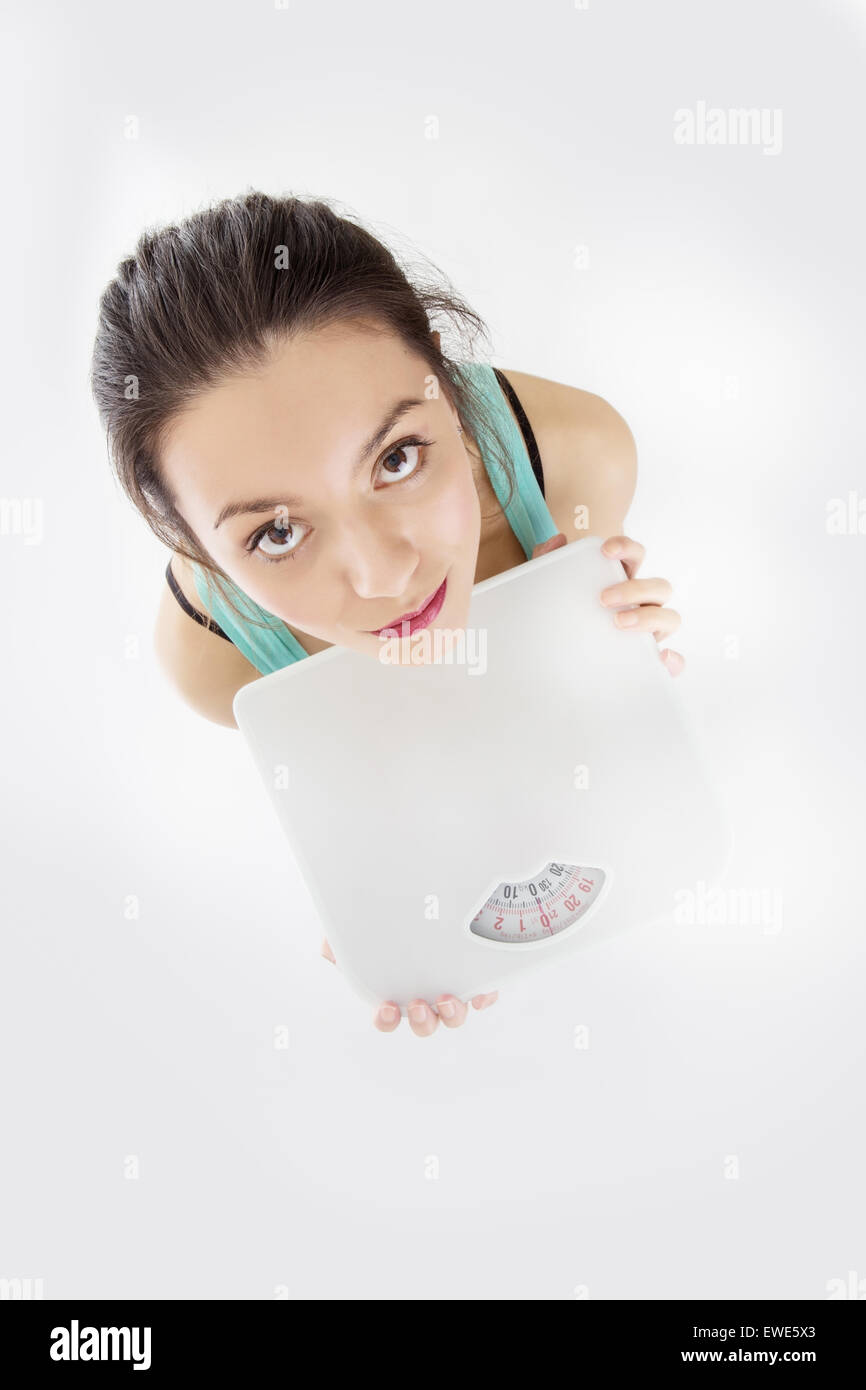 Woman shot from a birds eye view looking down holding scale an an apple ...