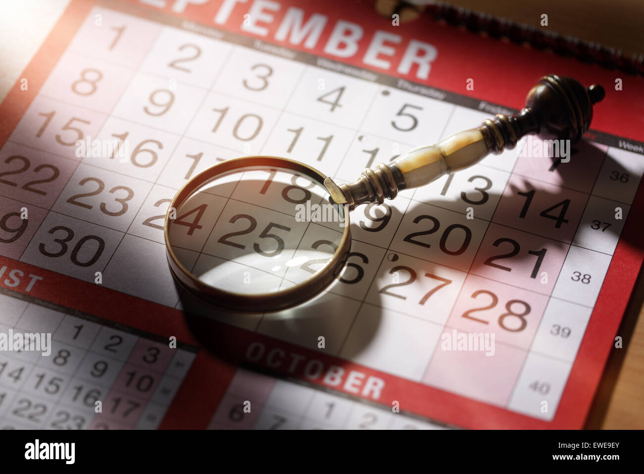 Calendar planning magnifying glass resting on an important date concept ...