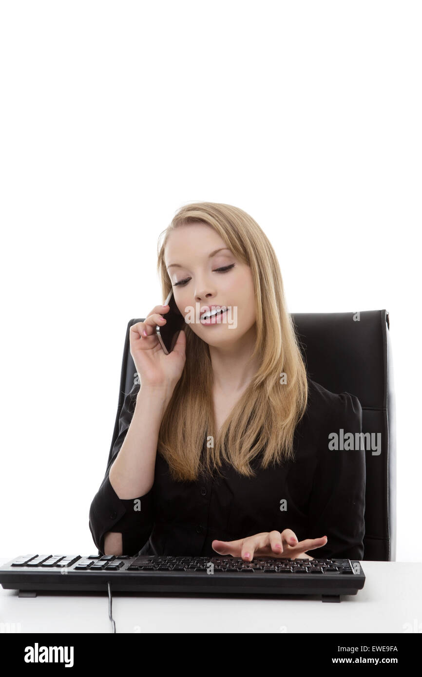 woman typing away on her keyboard hard at work and answering a mobile ...