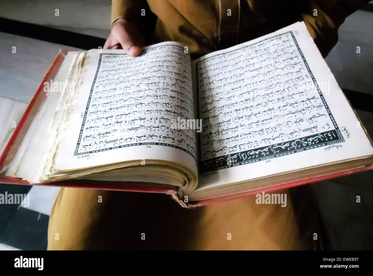Peshawar. 24th June, 2015. A Pakistani Muslim boy reads the holy book ...