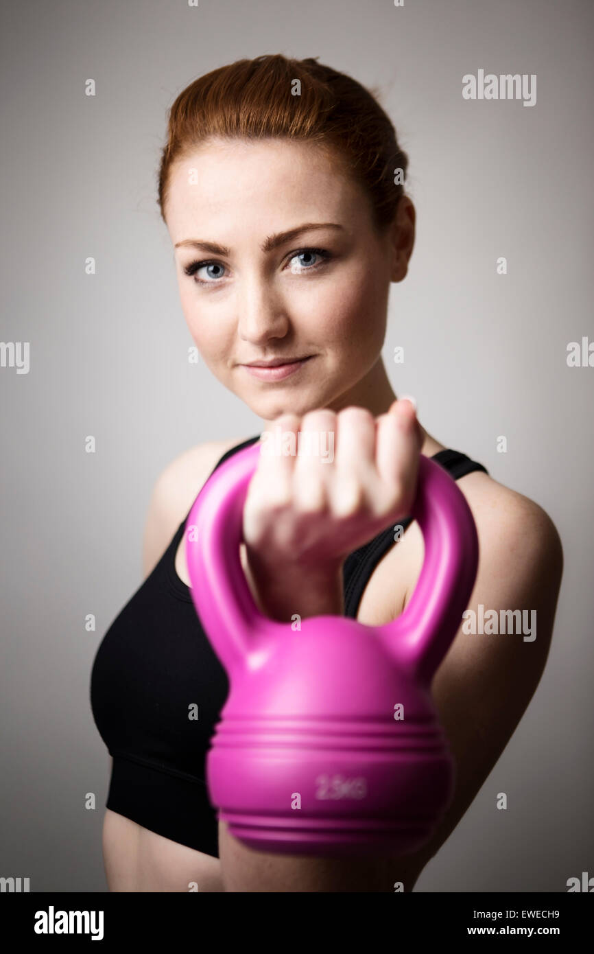 young woman working out lifting a kettlebell Stock Photo - Alamy