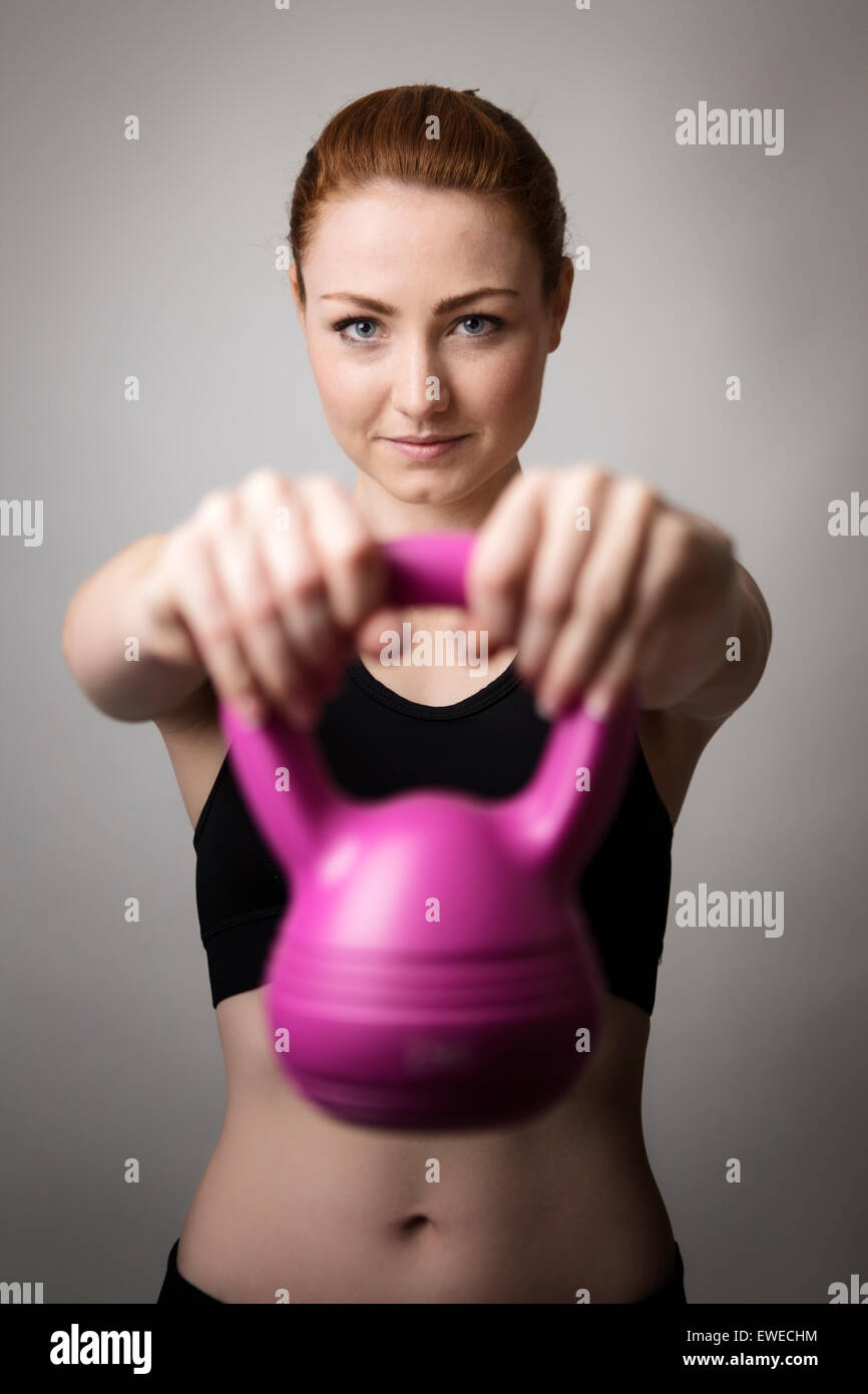young woman working out lifting a kettlebell Stock Photo - Alamy