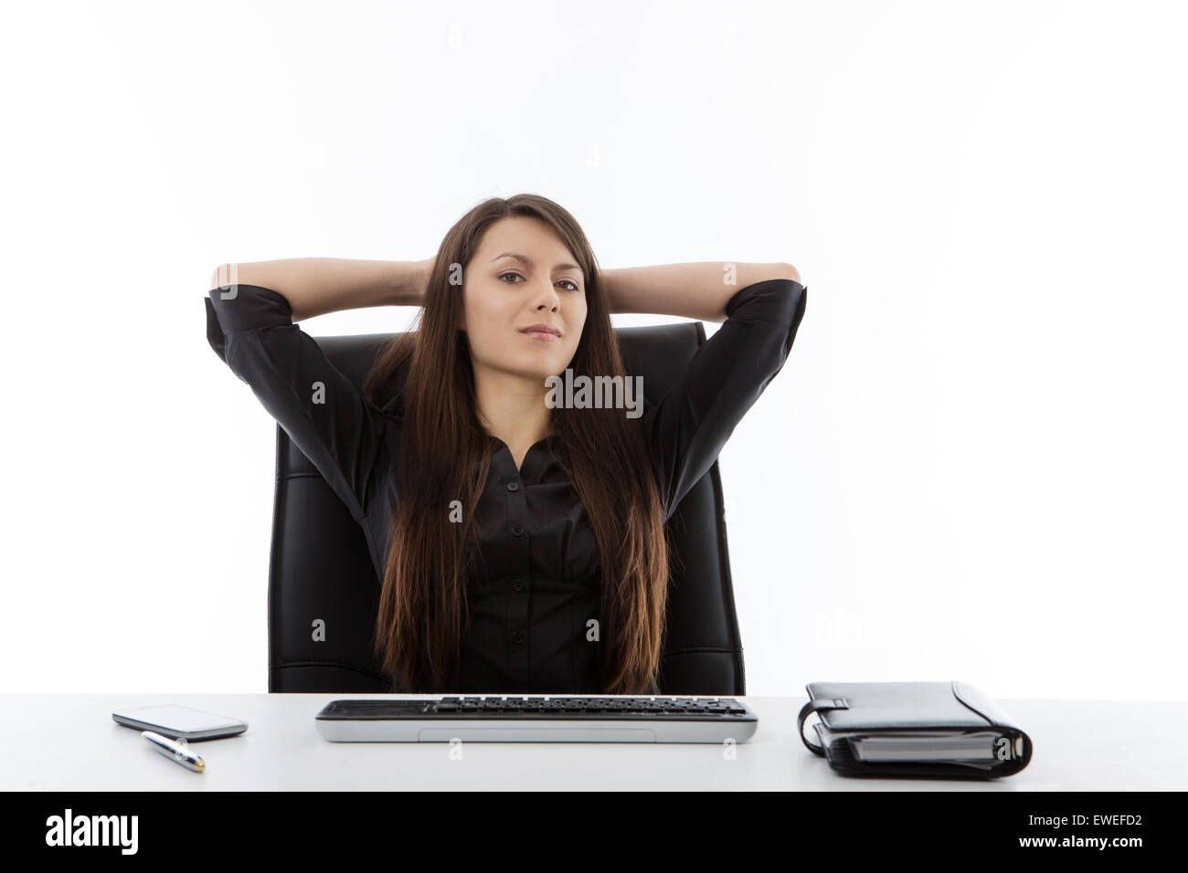 office worker sitting at her desk relaxing with her arms up Stock Photo ...
