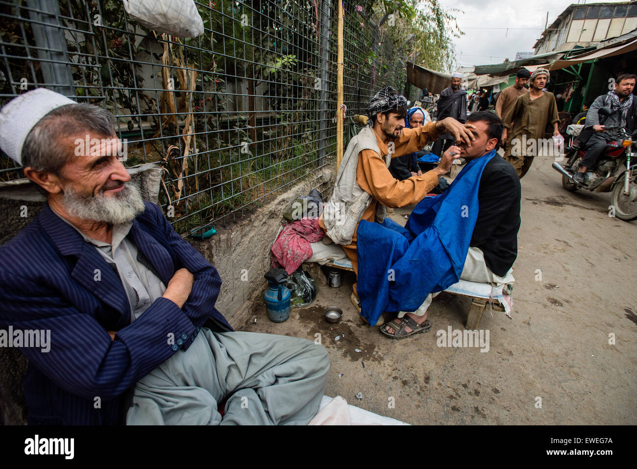 Barber shaves client on Bazaar street in Old city of Kabul, Afghanistan ...