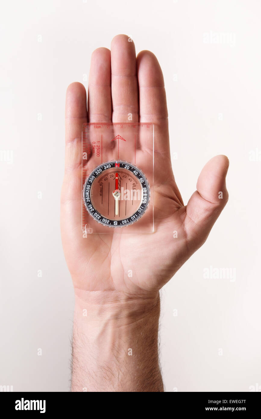 man's hand holding out a compass showing him the way shot in the studio ...