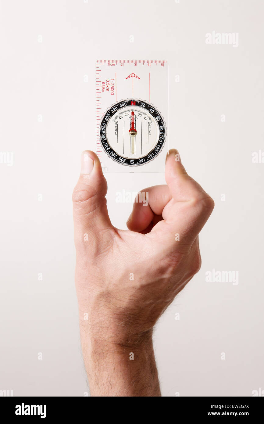 man's hand holding out a compass showing him the way shot in the studio ...
