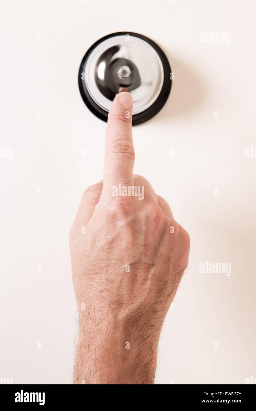 Shot from above of a man's hand pressing a service bell shot on a white ...