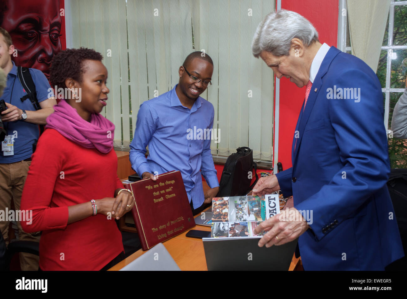 U.S. Secretary of State John Kerry listens as Nieri Mwangi describes a ...