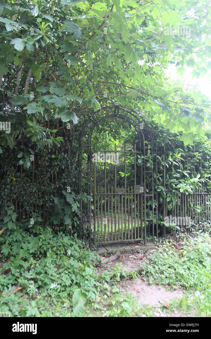 A wrought iron gate locked with private on the front, old and rusting ...