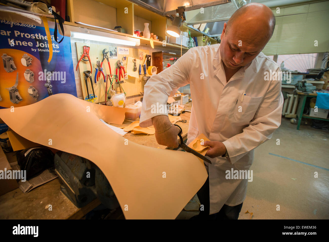 Worker cuts a detail for bionic prosthesis during Ukraine Prosthetic ...