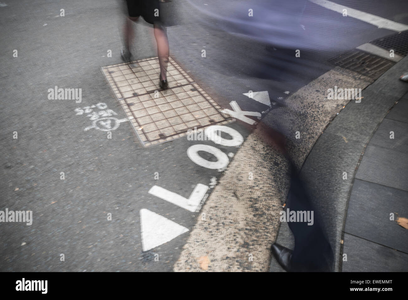 Pedestrian crossing road legs in movement with a look sign on the gound ...