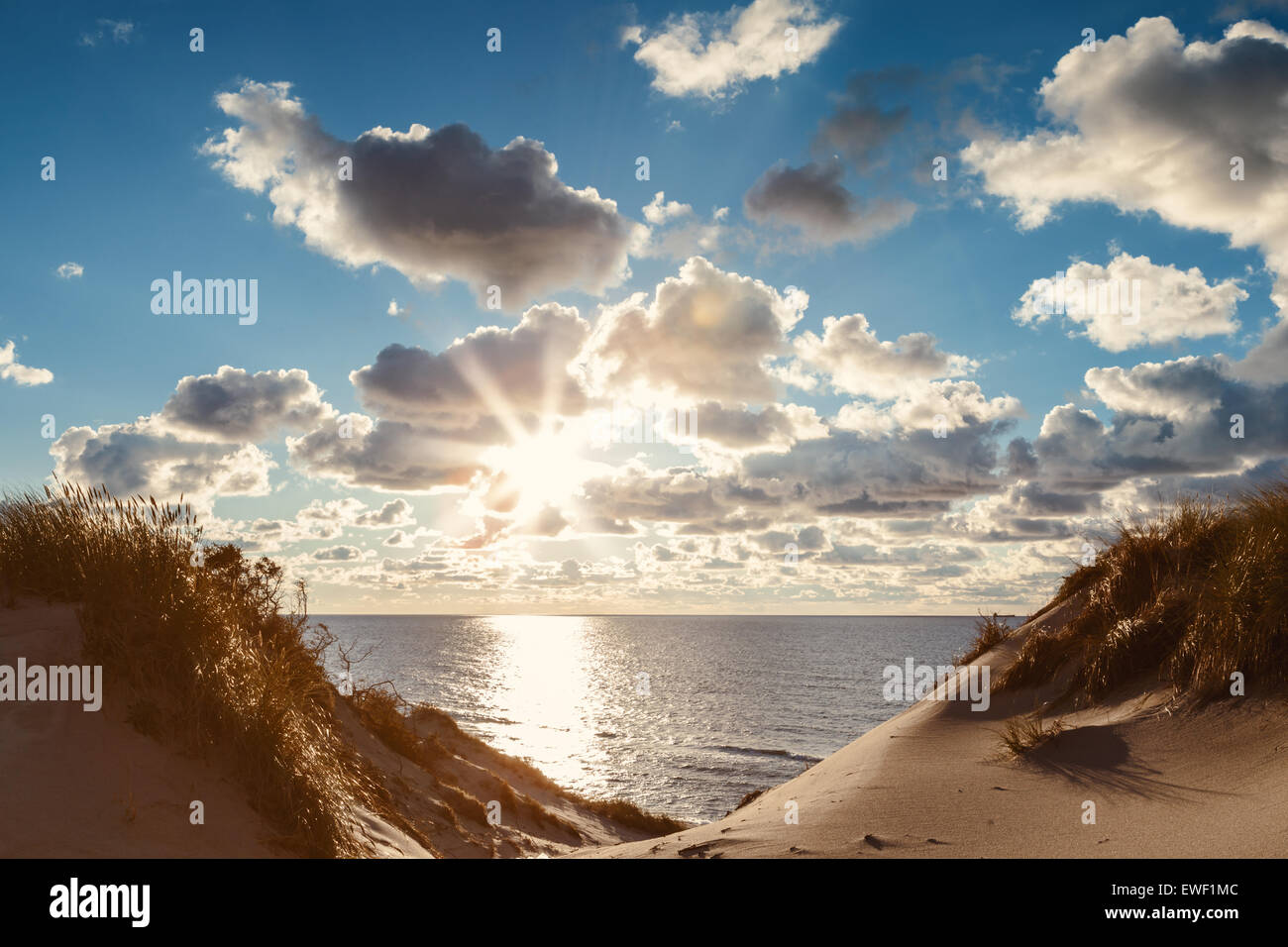 Sunset landscape with sun,clouds and dunes Stock Photo - Alamy