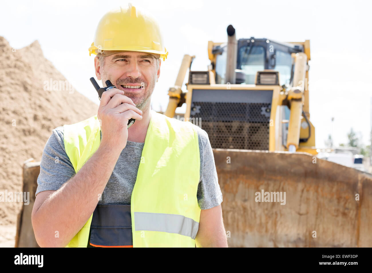 Confident supervisor using walkie-talkie at construction site Stock ...