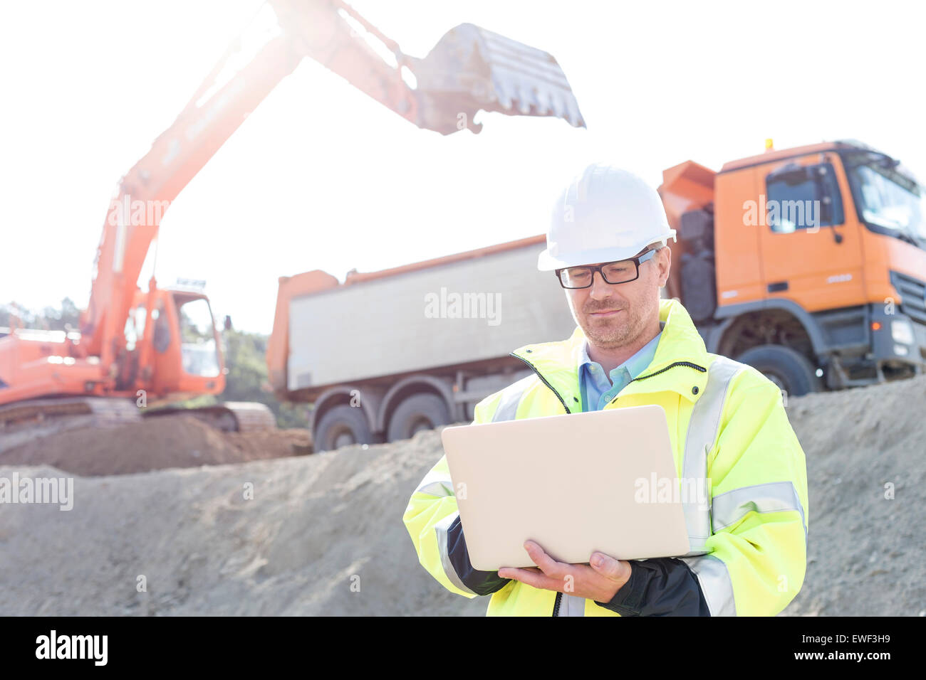 Supervisor using laptop at construction site on sunny day Stock Photo ...