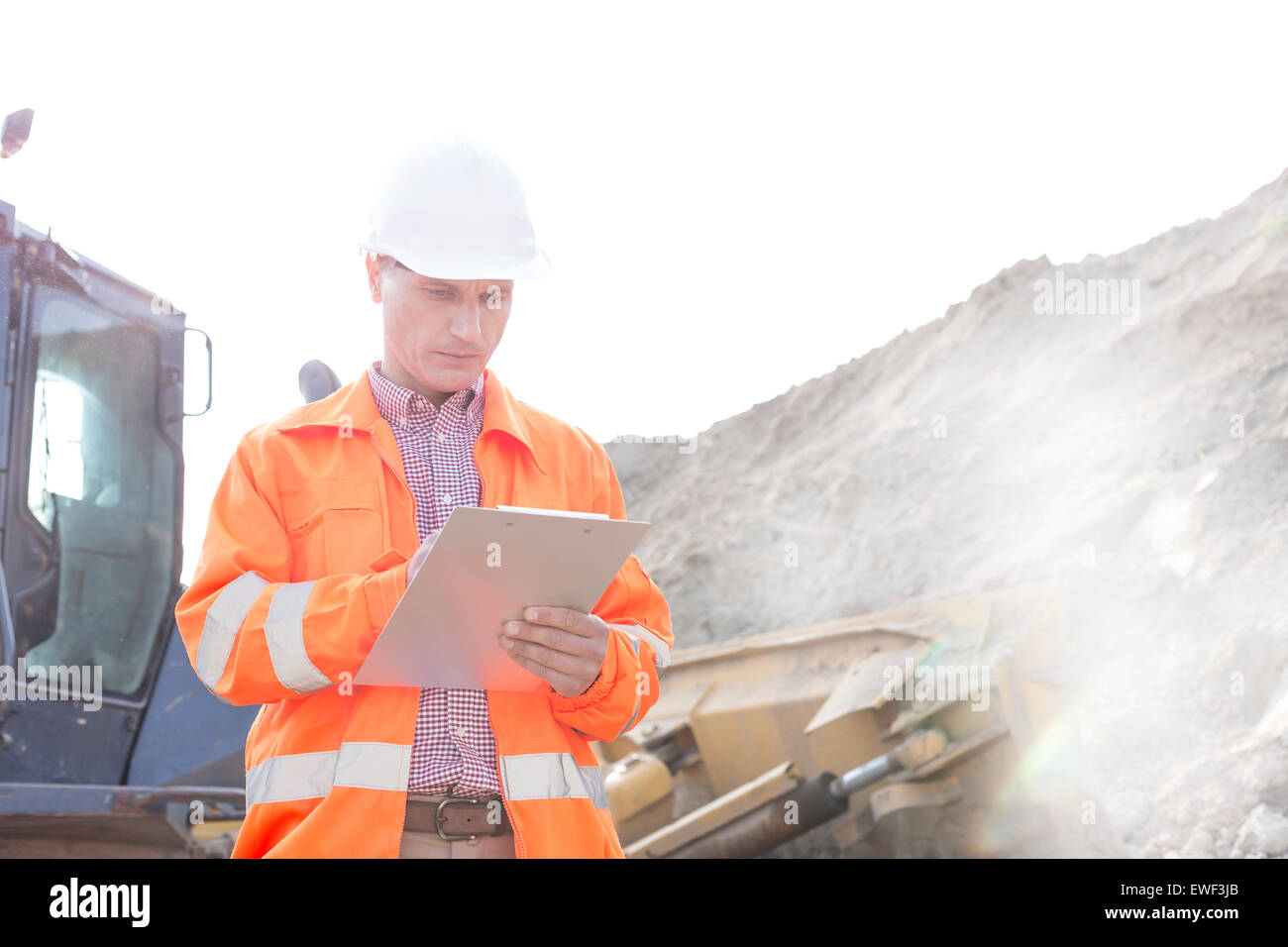 Engineer reading clipboard at construction site Stock Photo - Alamy