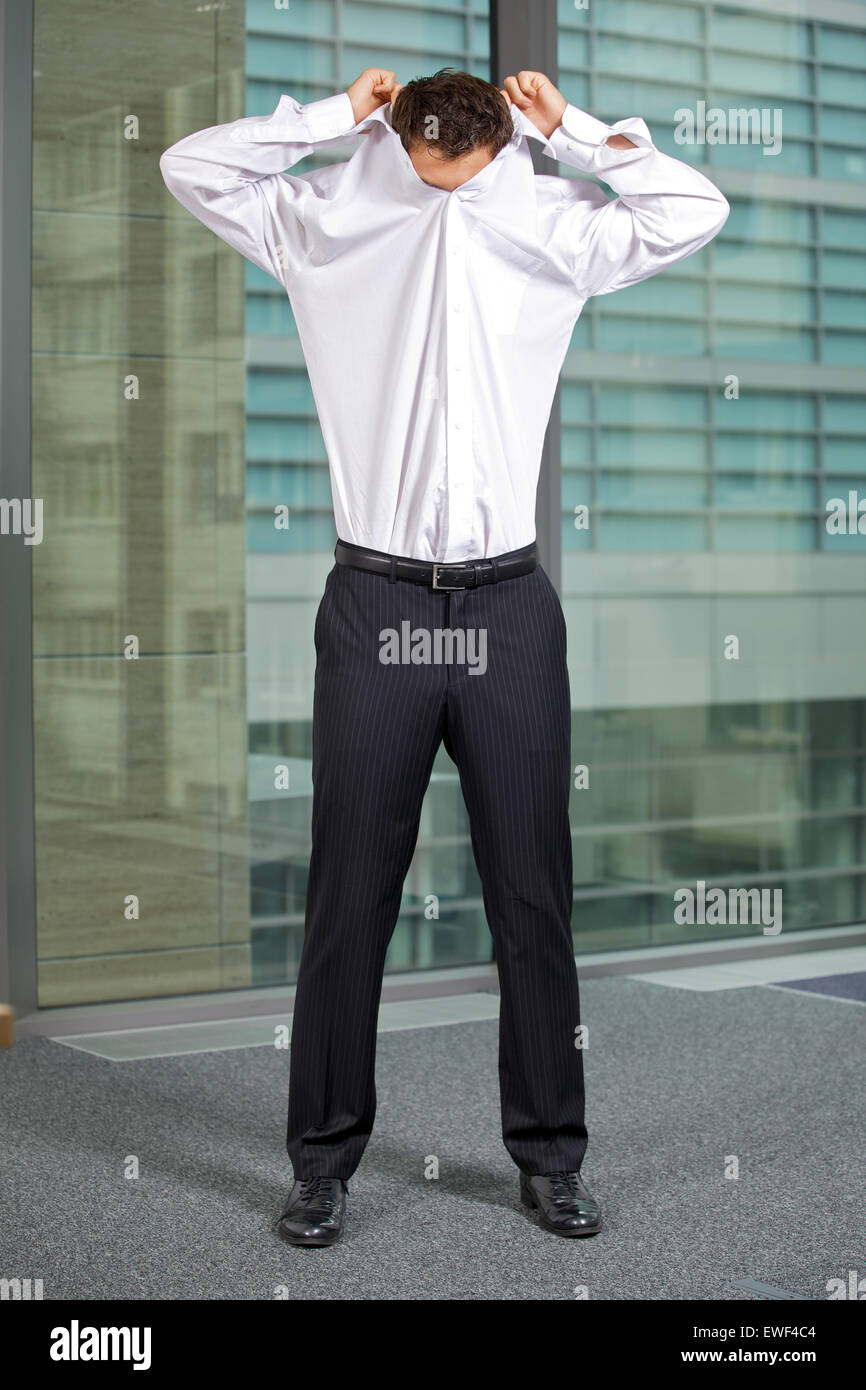 Businessman removing shirt at office Stock Photo - Alamy