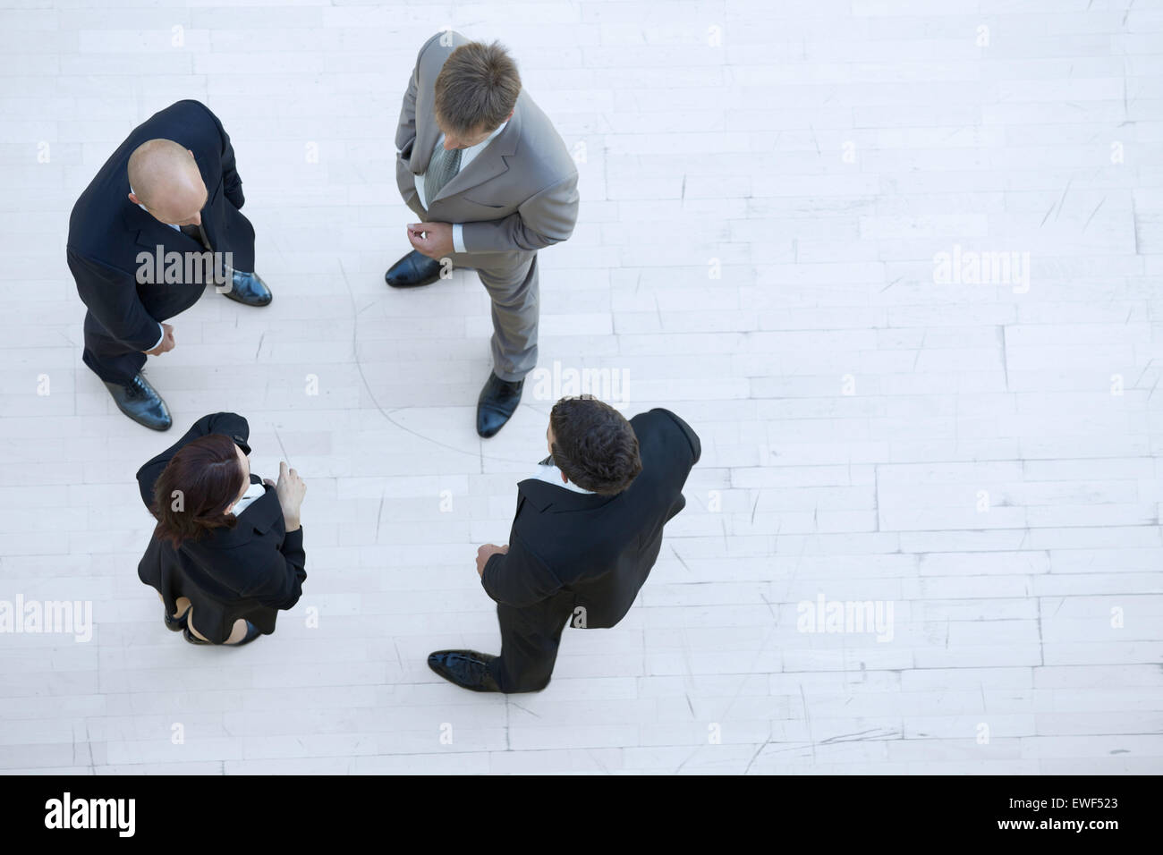 Businessmen and businesswoman standing together and conversing Stock ...
