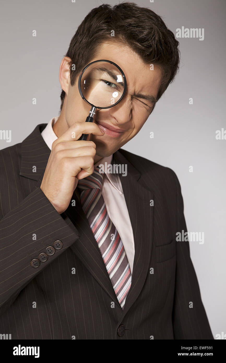 Young caucasian businessman with magnifying glass Stock Photo - Alamy